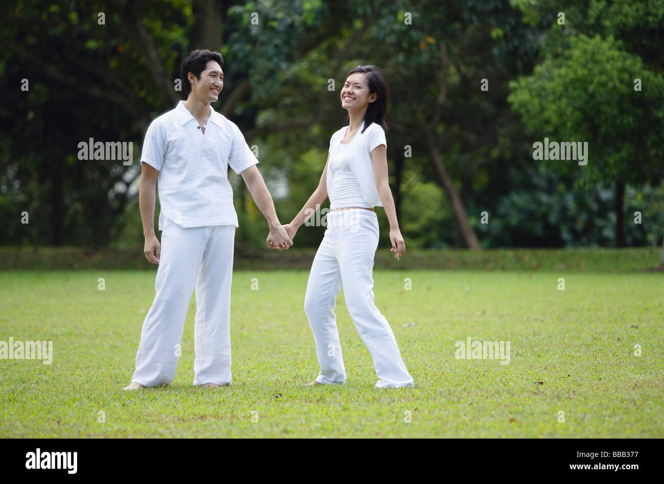 Couple standing, holding hands Stock Photo - Alamy