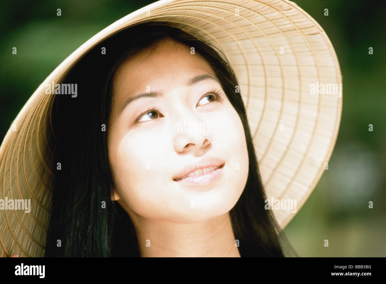 Young woman wearing straw hat, looking up Stock Photo - Alamy