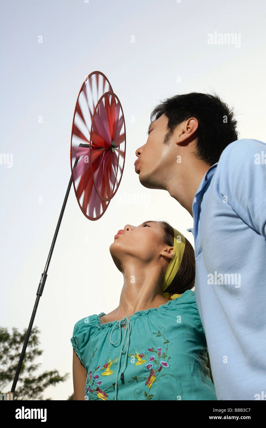 A couple blow on a windmill together Stock Photo - Alamy