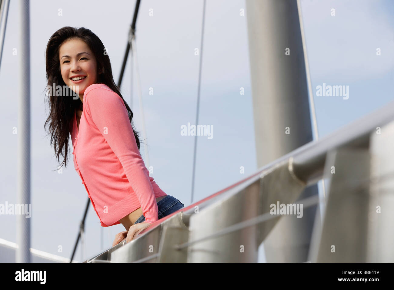 Young woman leaning over bridge Stock Photo - Alamy