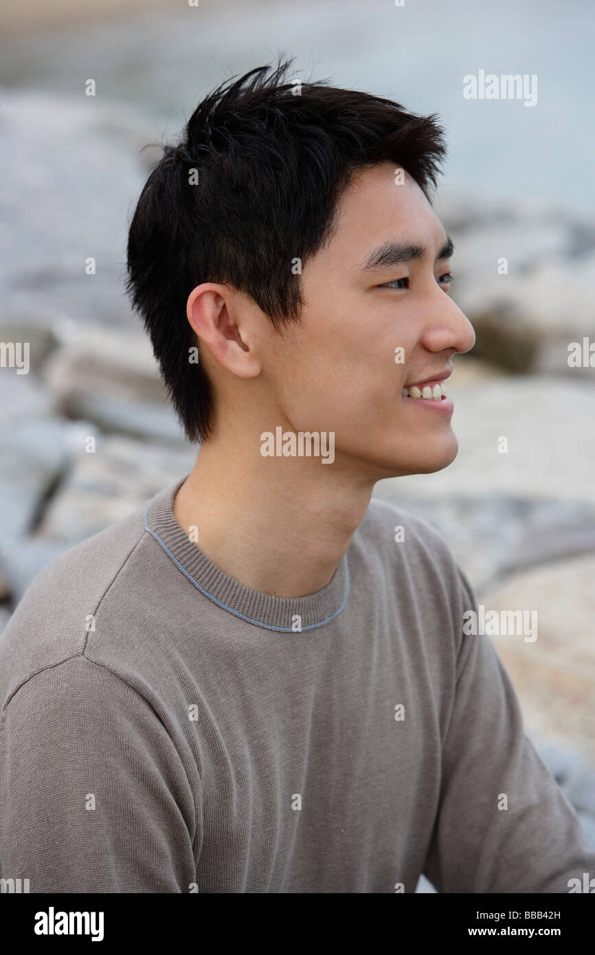 Profile of man sitting on seashore Stock Photo - Alamy