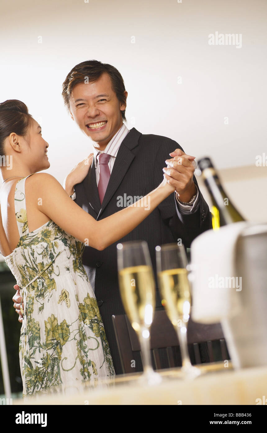 Couple dancing, champagne glasses and bottle in foreground Stock Photo ...