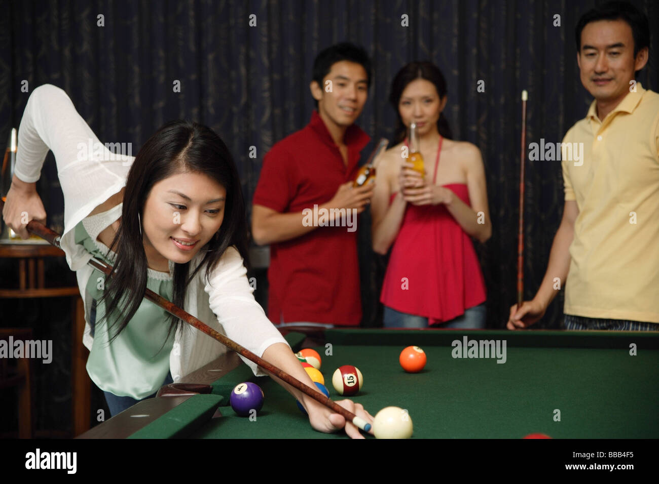 Woman playing snooker, people watching Stock Photo - Alamy