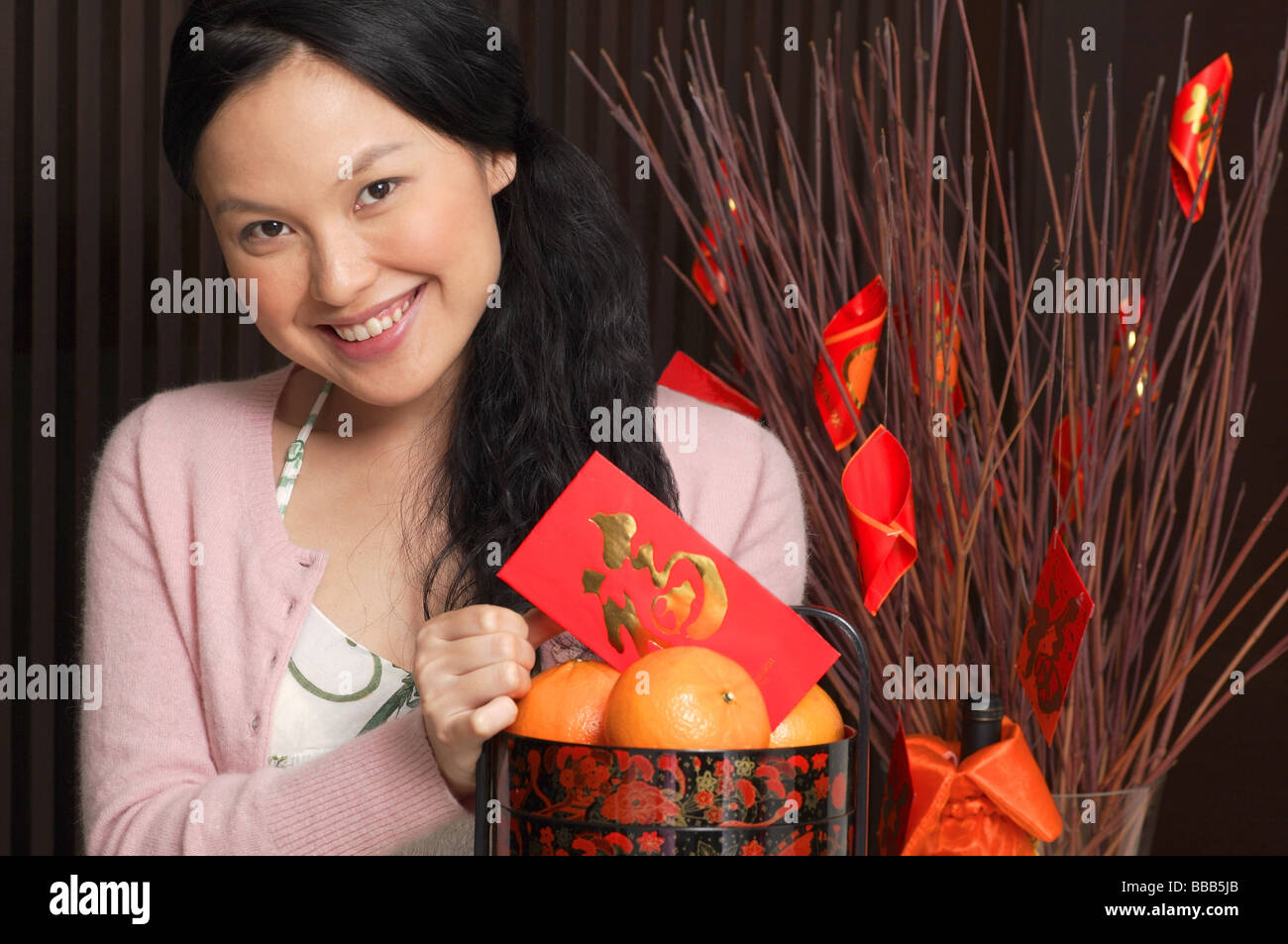 Woman with basket of oranges and red packet Stock Photo - Alamy