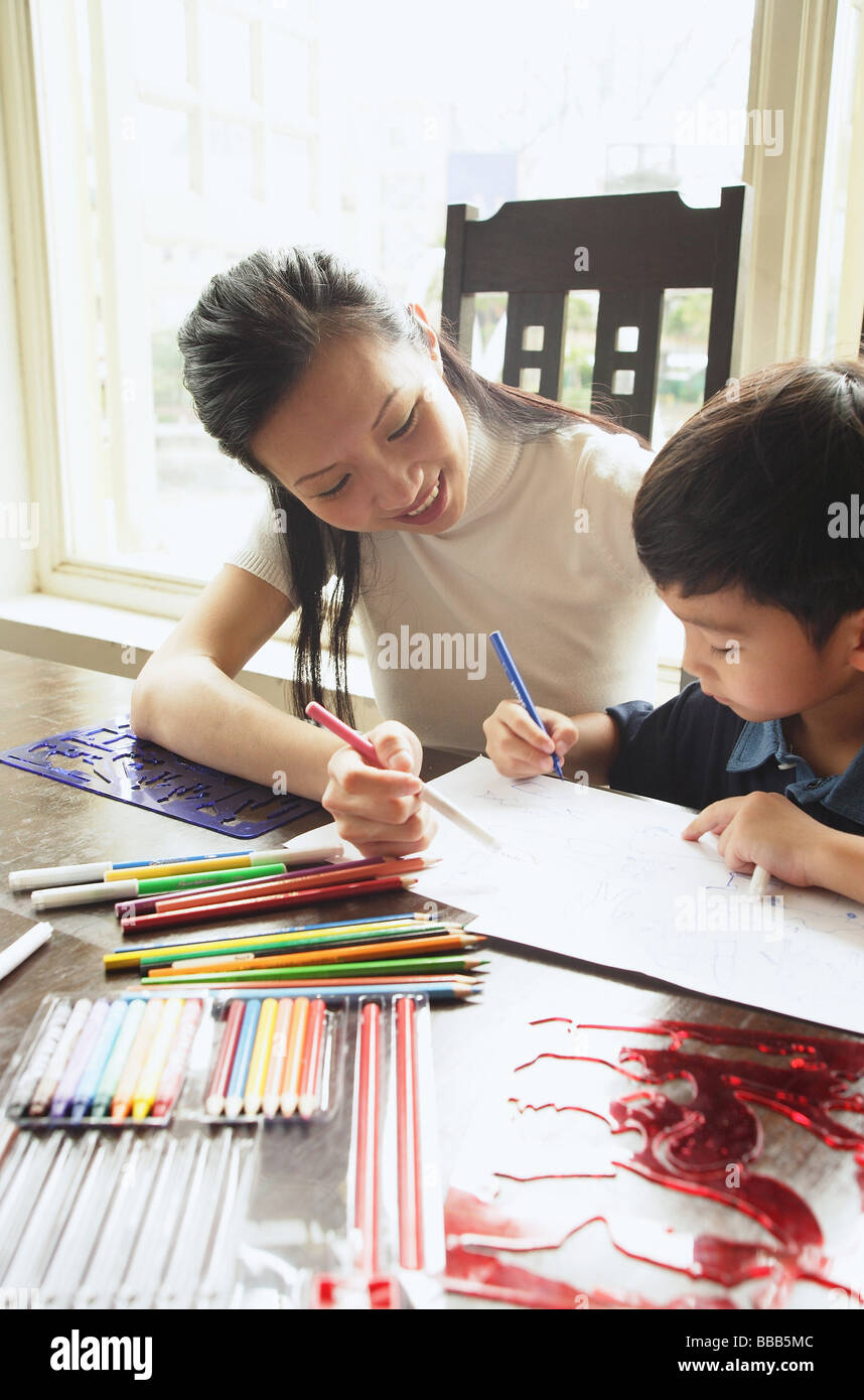 Mother sitting with son, drawing with colour pencils Stock Photo - Alamy