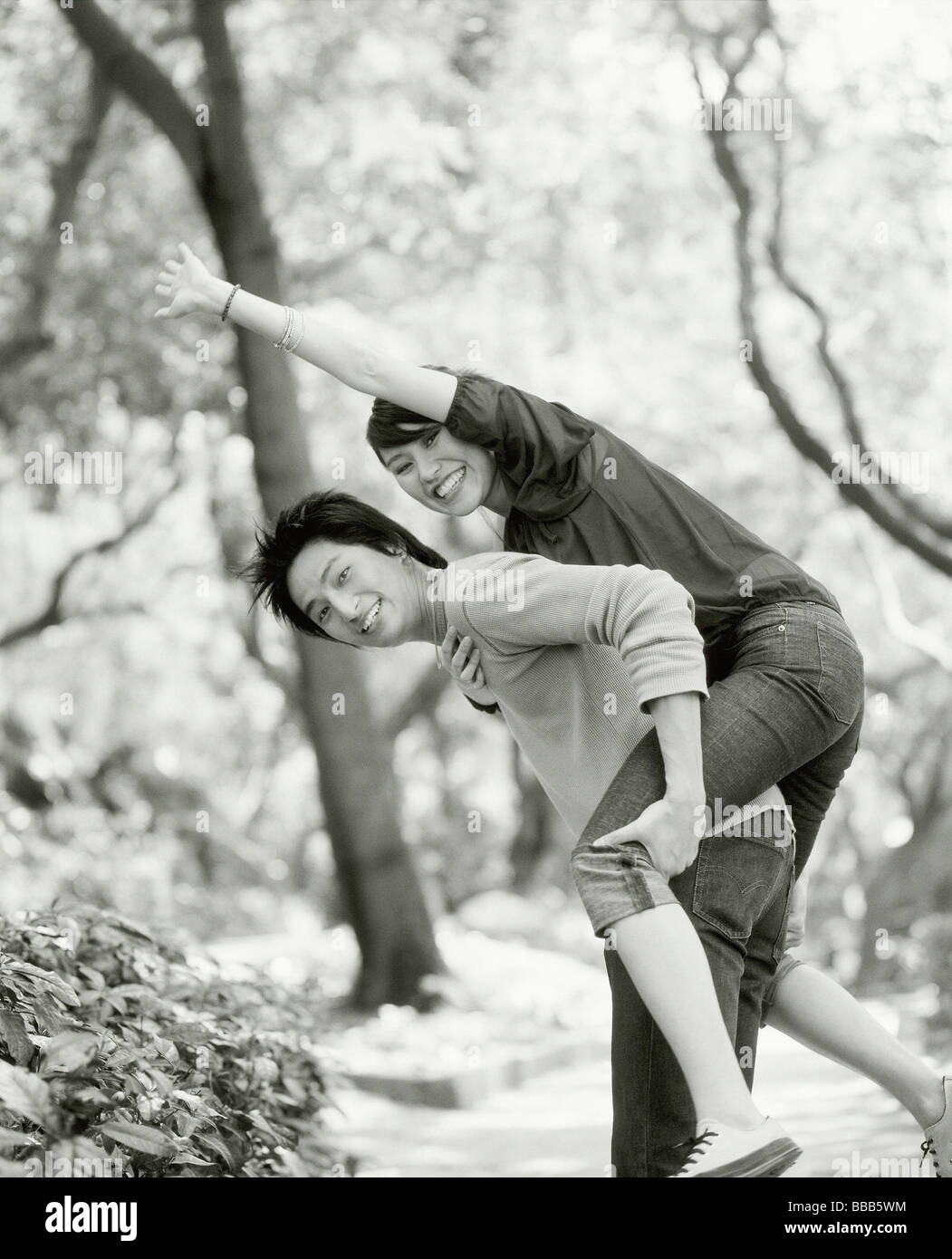 Young man piggybacking woman on nature path Stock Photo - Alamy