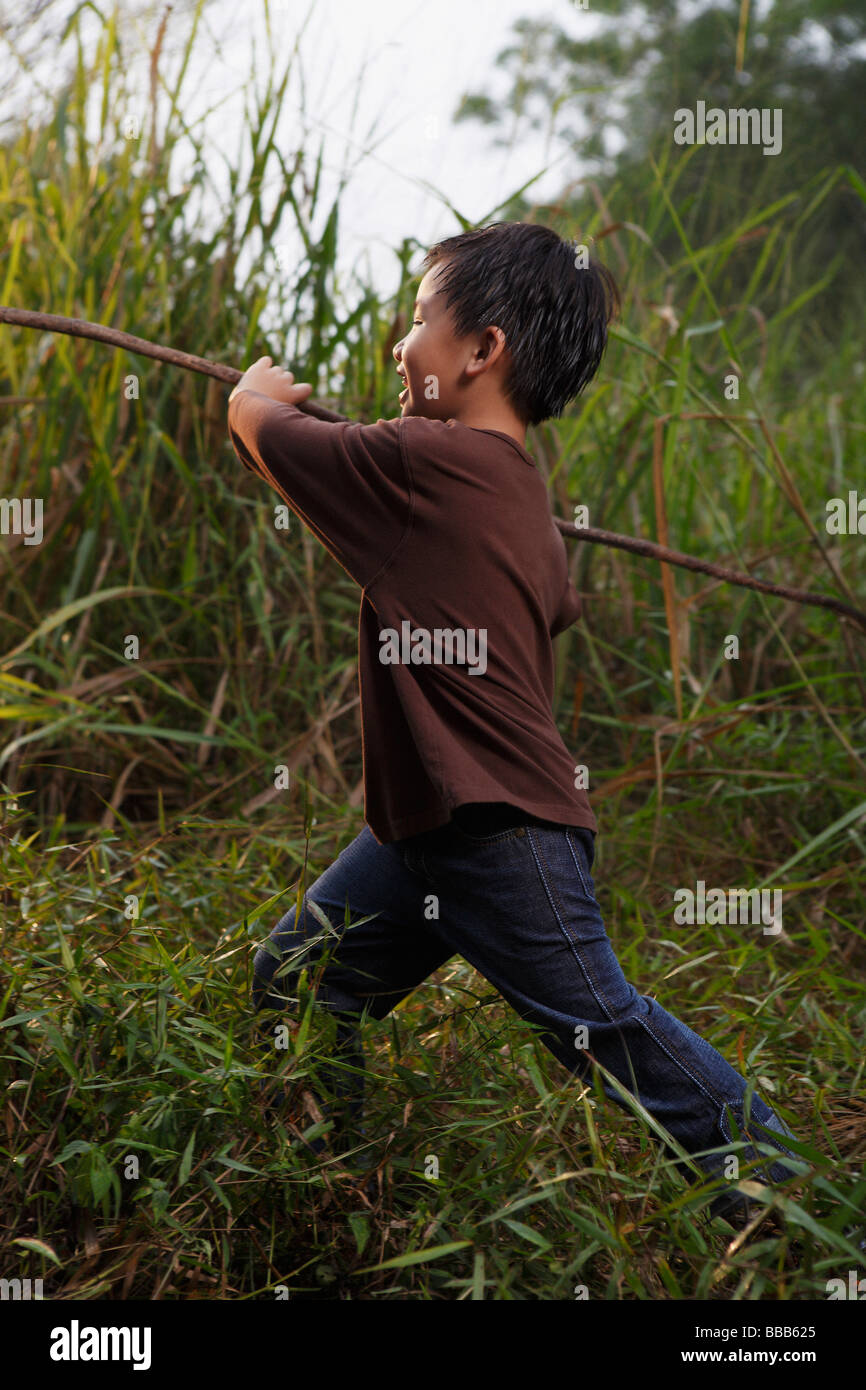 Boy running with stick Stock Photo - Alamy