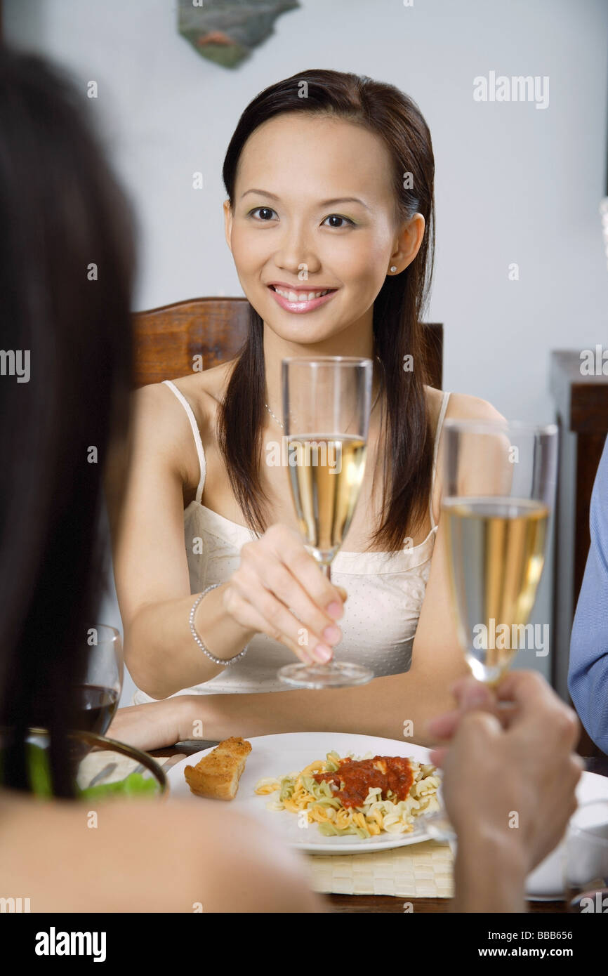 Woman raising glass in toast Stock Photo - Alamy