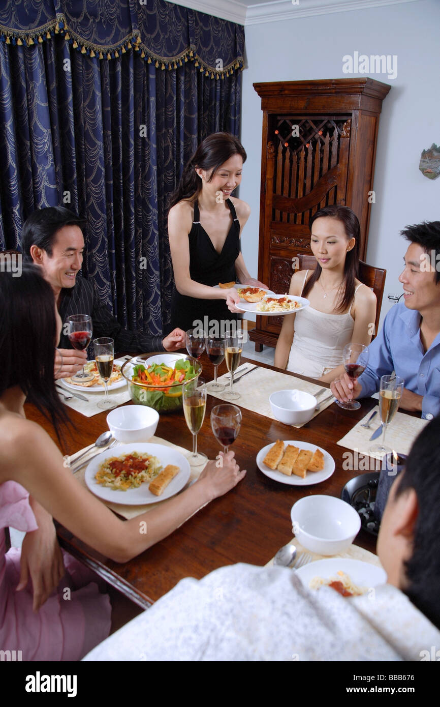 Couples having dinner at home, woman serving food Stock Photo - Alamy