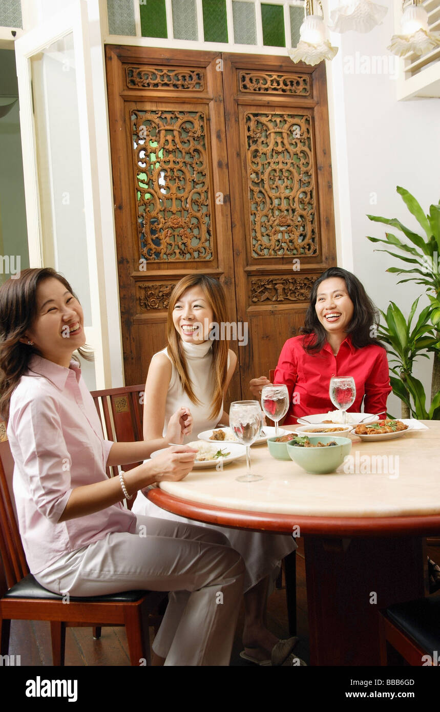 Three women having a meal at restaurant, laughing Stock Photo - Alamy