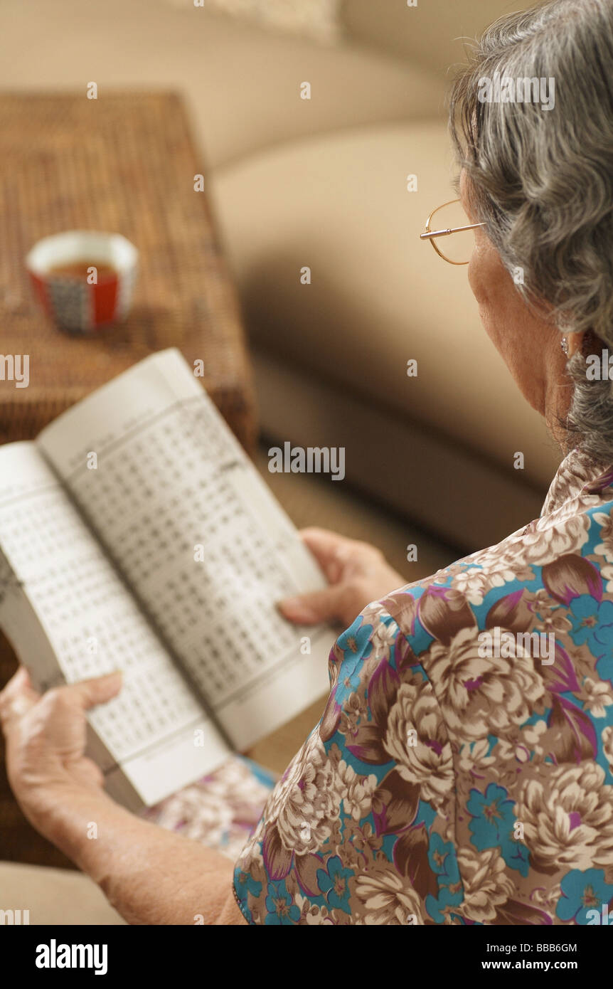 Senior woman reading a book, over the shoulder view Stock Photo - Alamy