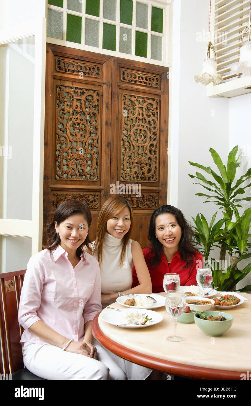 Three women at a restaurant sitting, looking at camera Stock Photo - Alamy