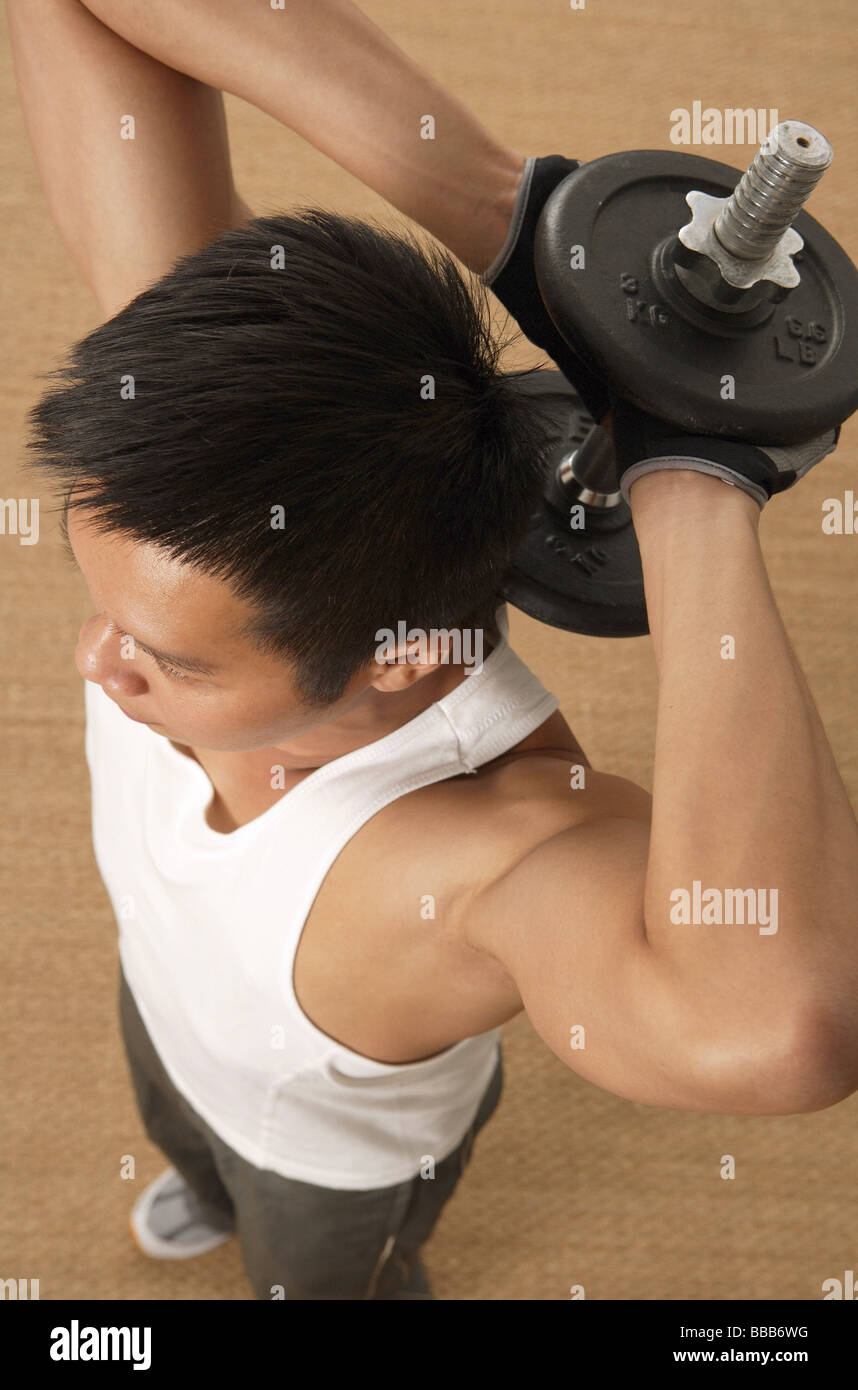 Man lifting dumbbells over shoulder, high angle view Stock Photo - Alamy