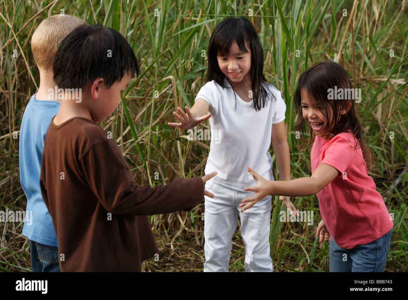 Four children playing outside Stock Photo - Alamy