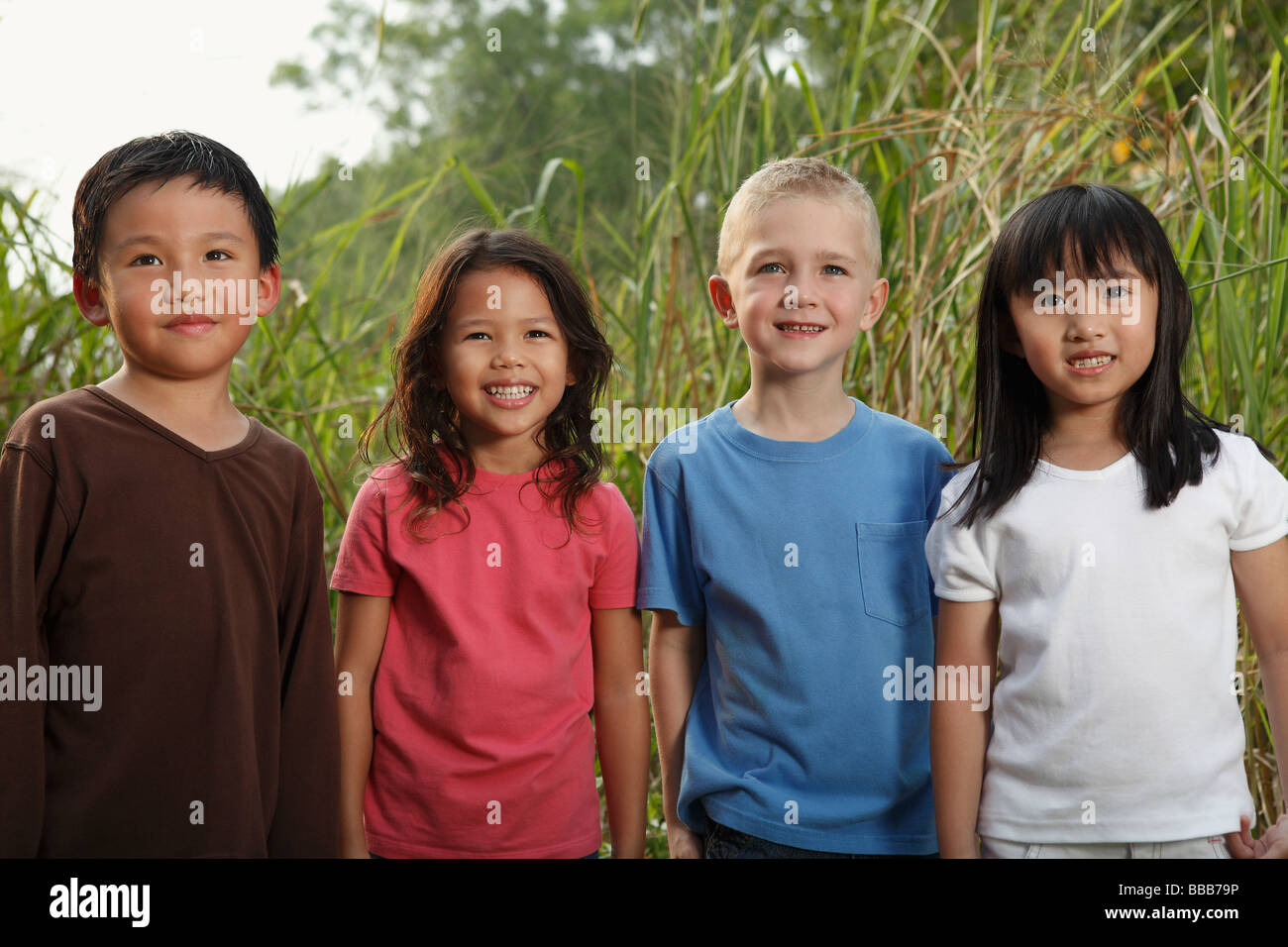 Four children standing together, smiling Stock Photo - Alamy
