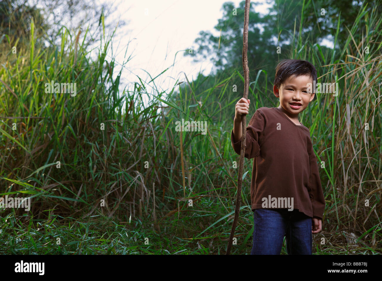 Boy holding stick Stock Photo - Alamy