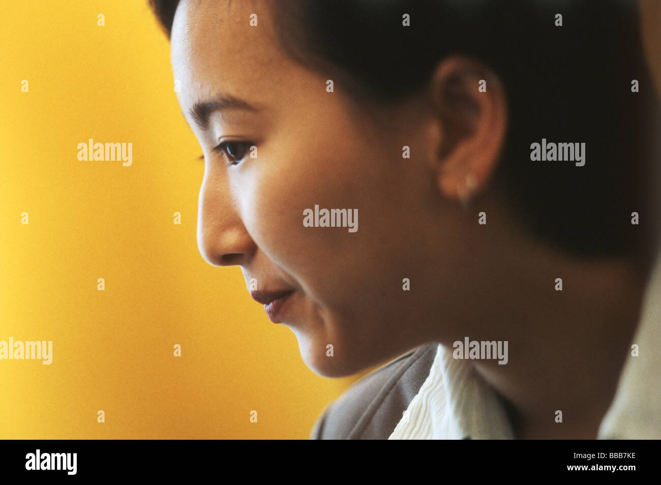 Female executive, profile, yellow background Stock Photo - Alamy