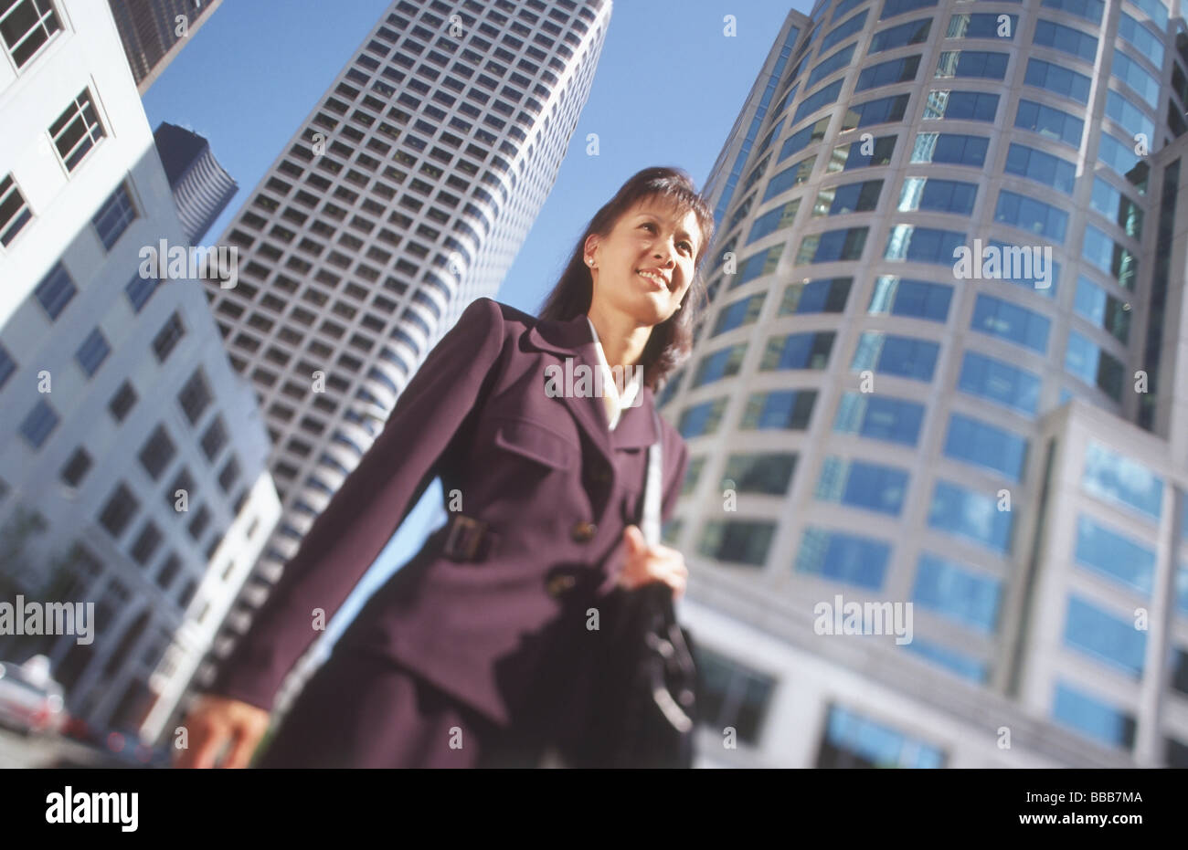 Female executive standing in front of office buildings, low angle view ...