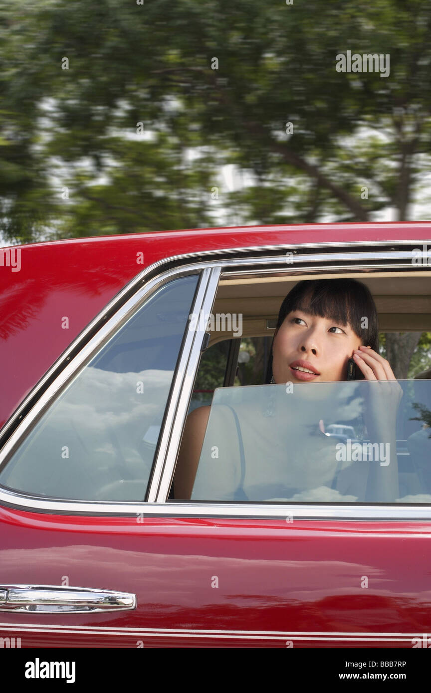 Woman Sitting In Car Using Mobile Phone Looking Through The Window