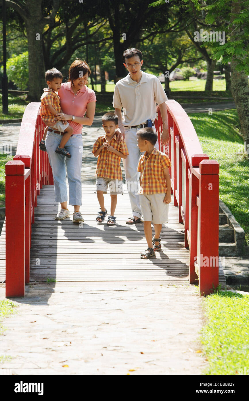 Family with three boys walking across bridge Stock Photo - Alamy