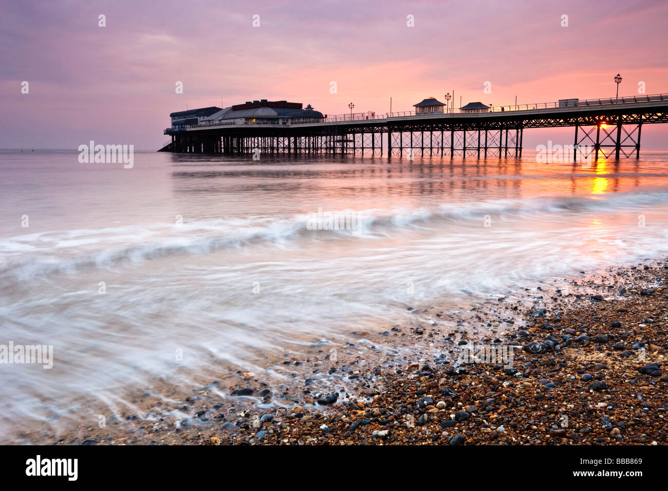 Cromer pier at dawn The wave caught as it drawers back across the ...