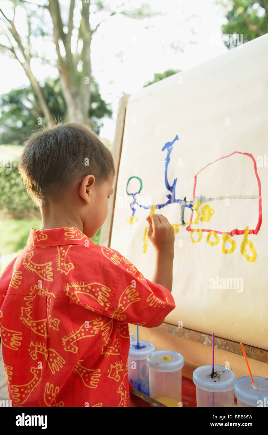 Boy drawing on easel, over the shoulder view Stock Photo - Alamy