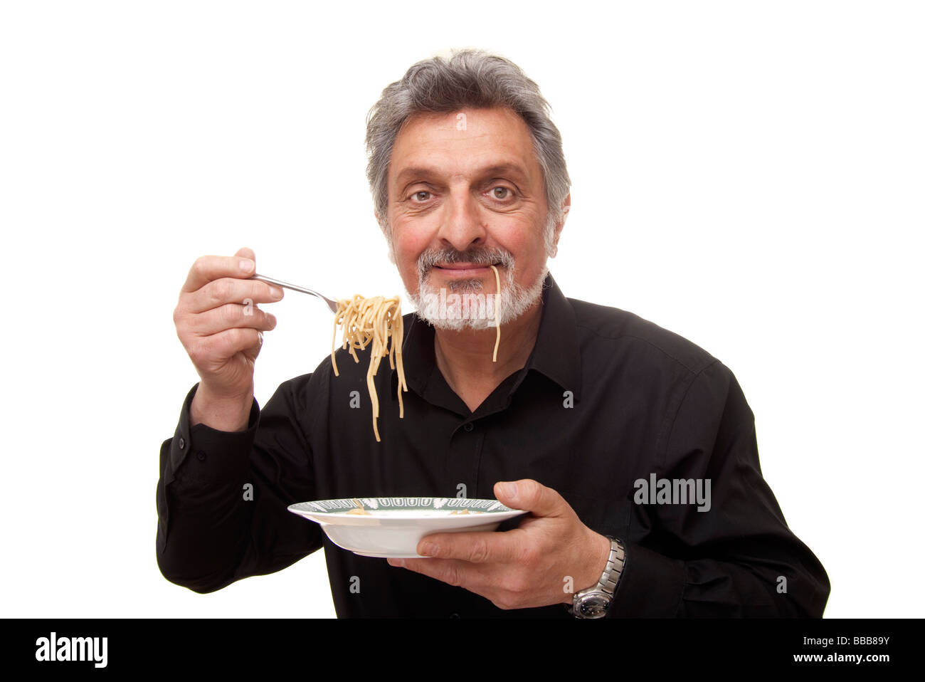 man eating a bowl of pasta with spaghetti hanging from his mouth Stock ...
