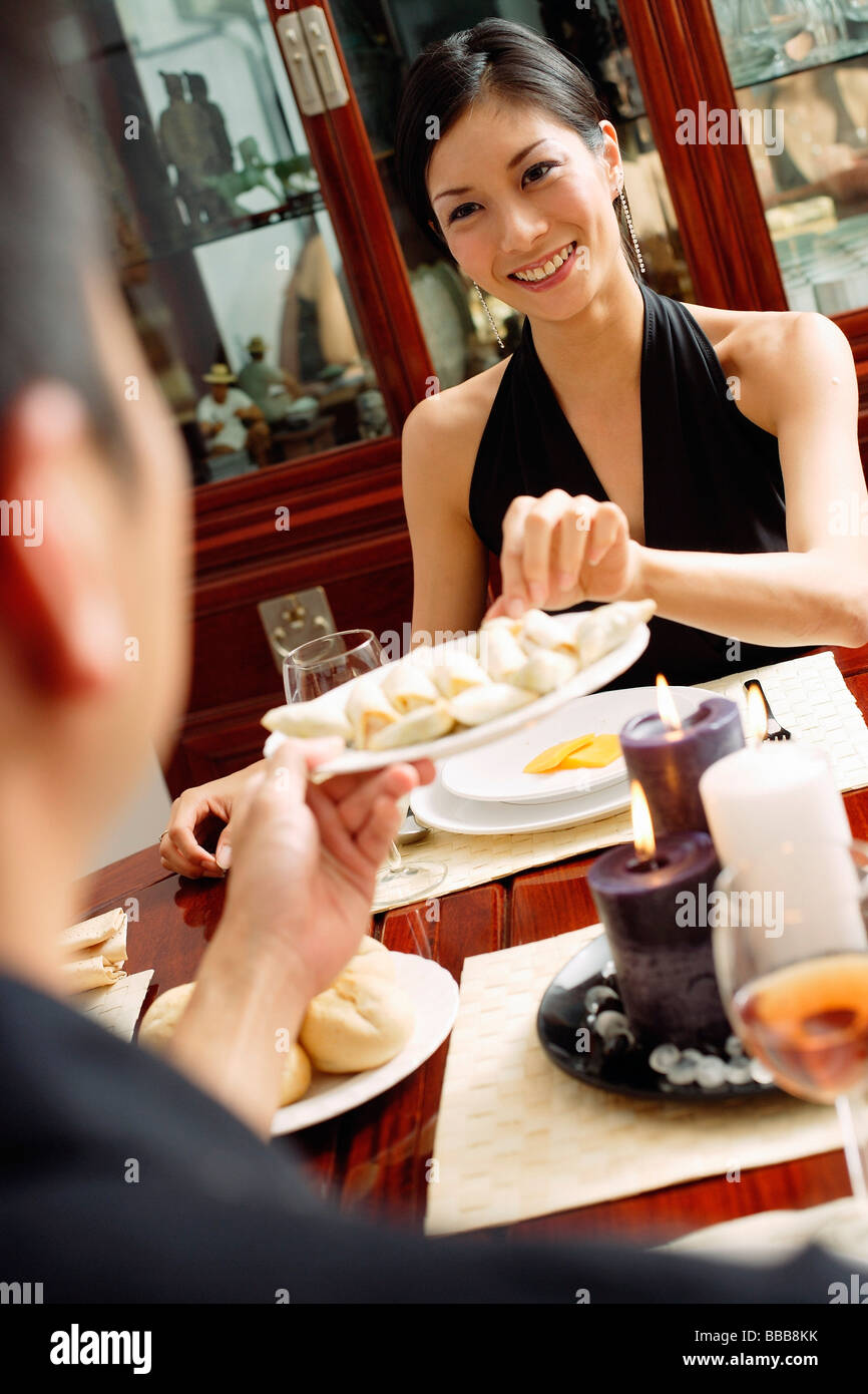 Man holding plate of food, woman taking from it Stock Photo - Alamy