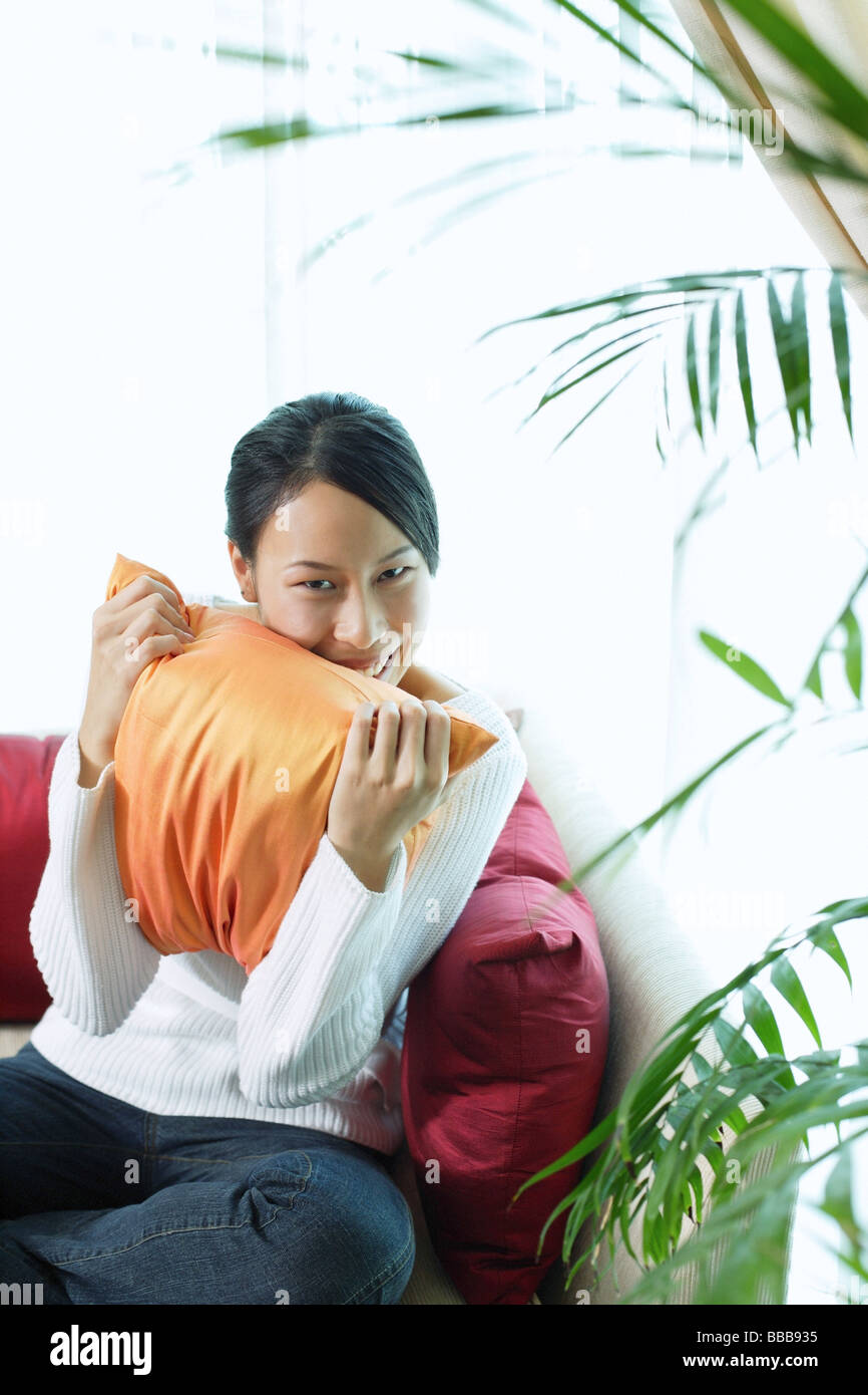 Woman hugging pillow, smiling at camera, portrait Stock Photo - Alamy