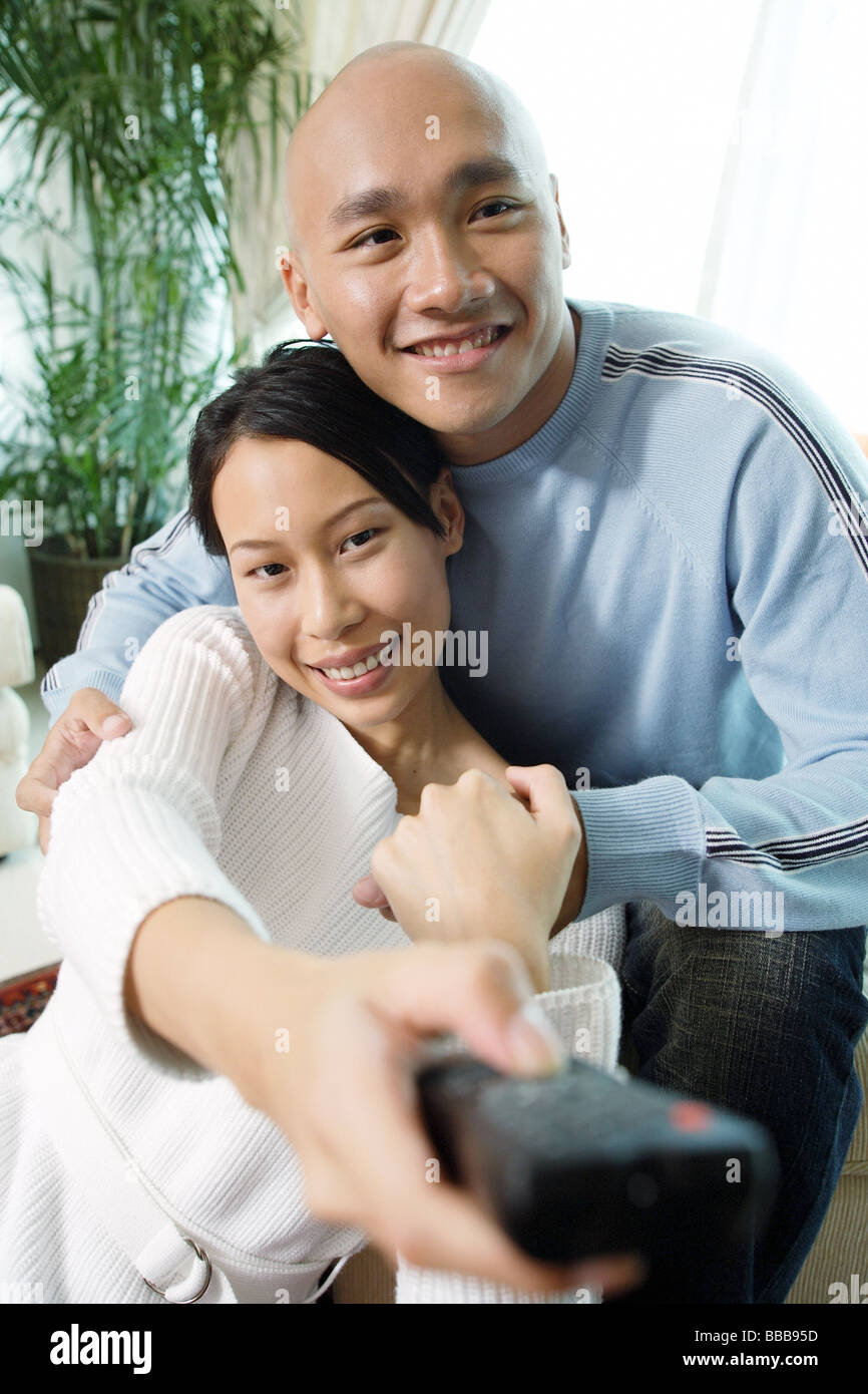 Couple in living room, woman holding remote control forward Stock Photo ...