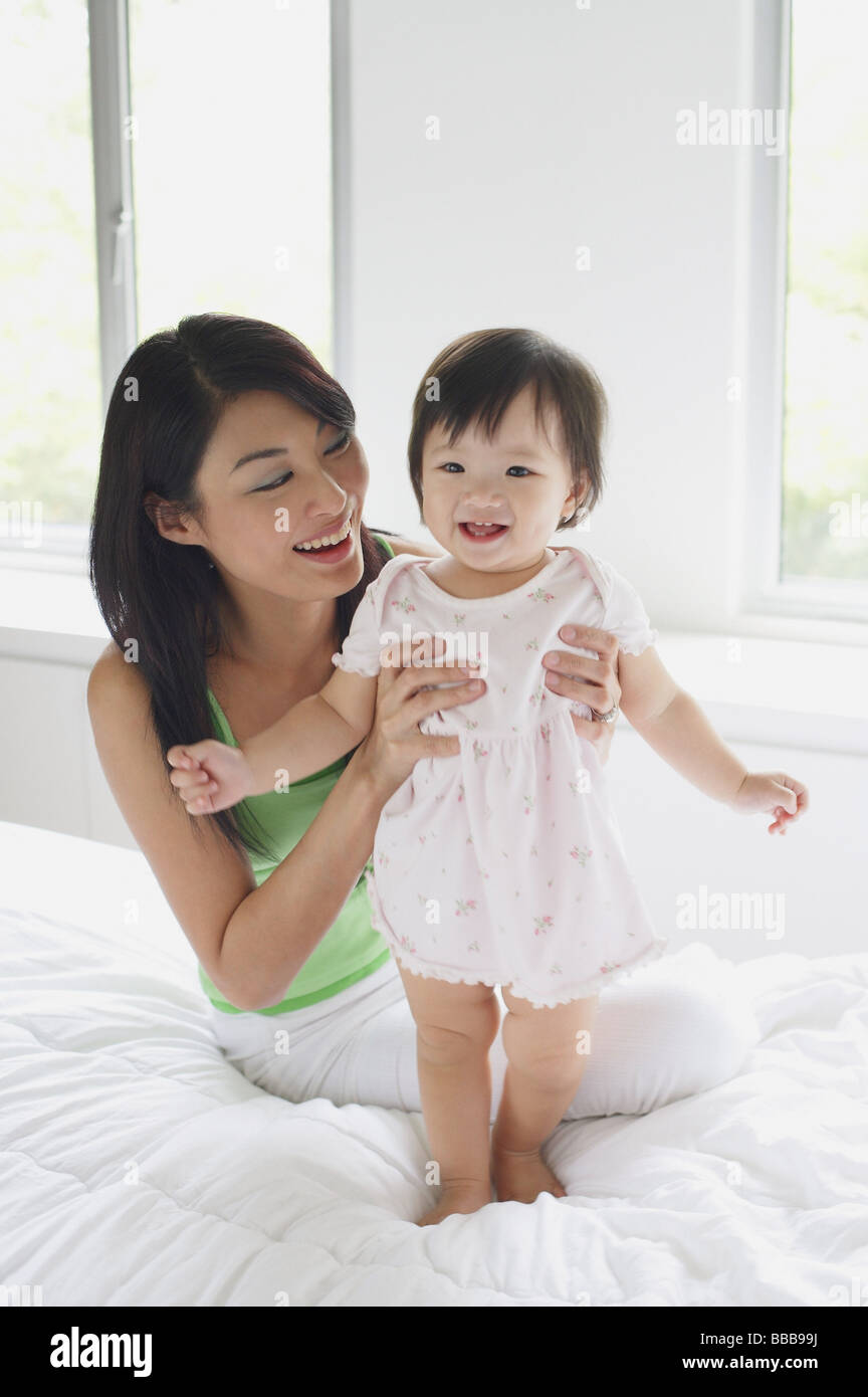 Young girl standing, mother supporting her Stock Photo - Alamy