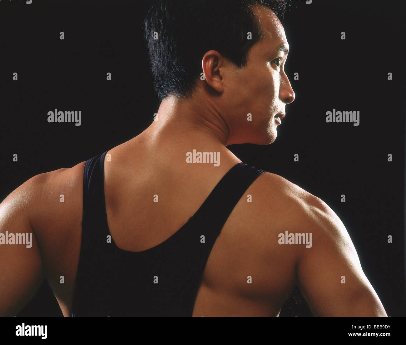 Male athlete, rear view, profile, black background Stock Photo - Alamy