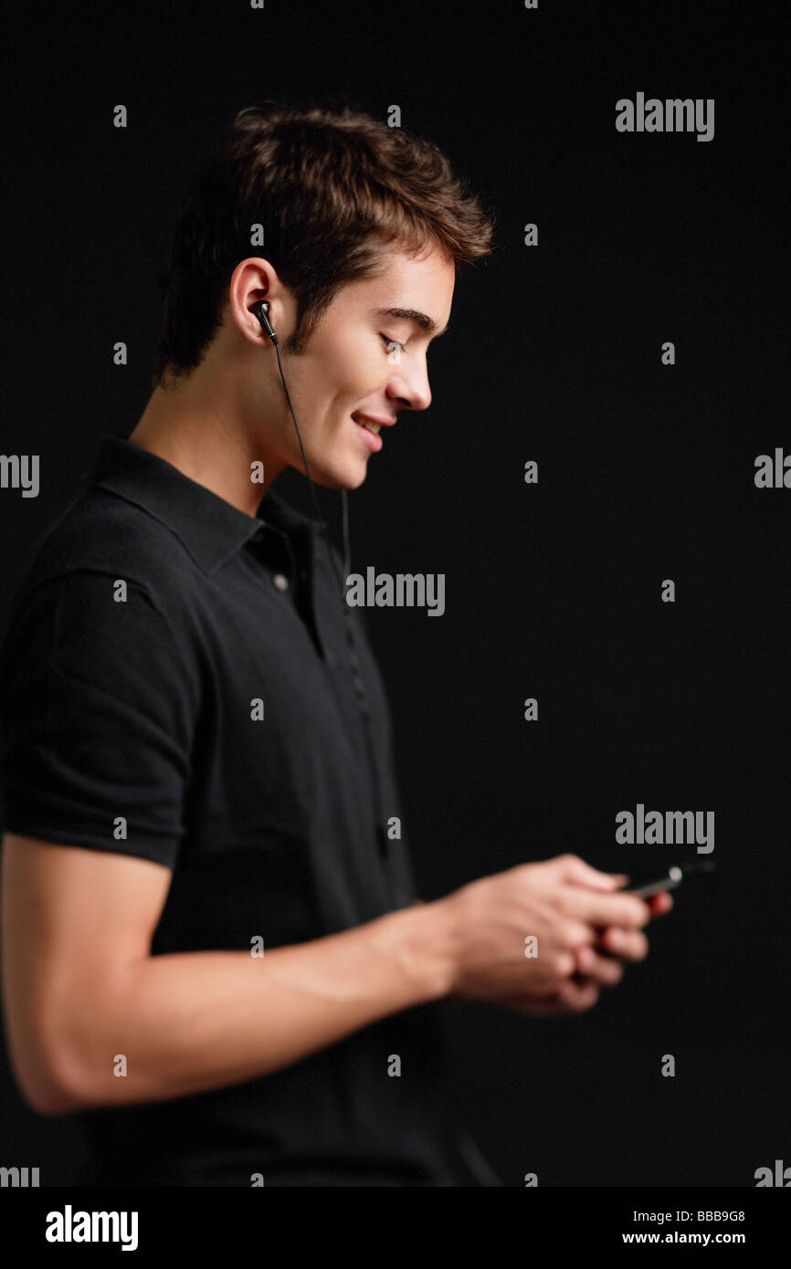 Man listening to MP3 player, side view Stock Photo - Alamy