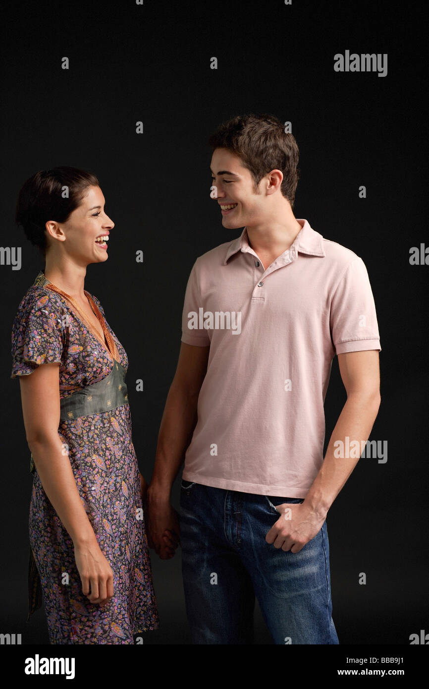 Couple standing, smiling at each other Stock Photo - Alamy