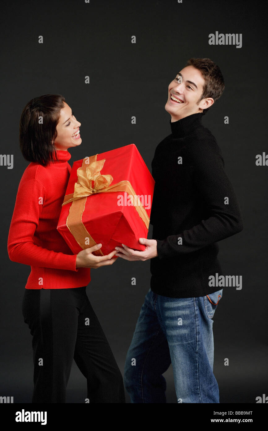 Man passing gift to woman Stock Photo - Alamy