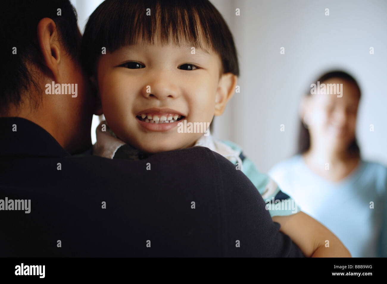 Young boy looking over father's shoulder Stock Photo - Alamy