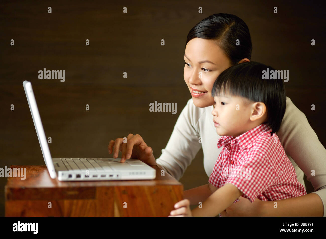 Mother with young son, looking at laptop Stock Photo - Alamy