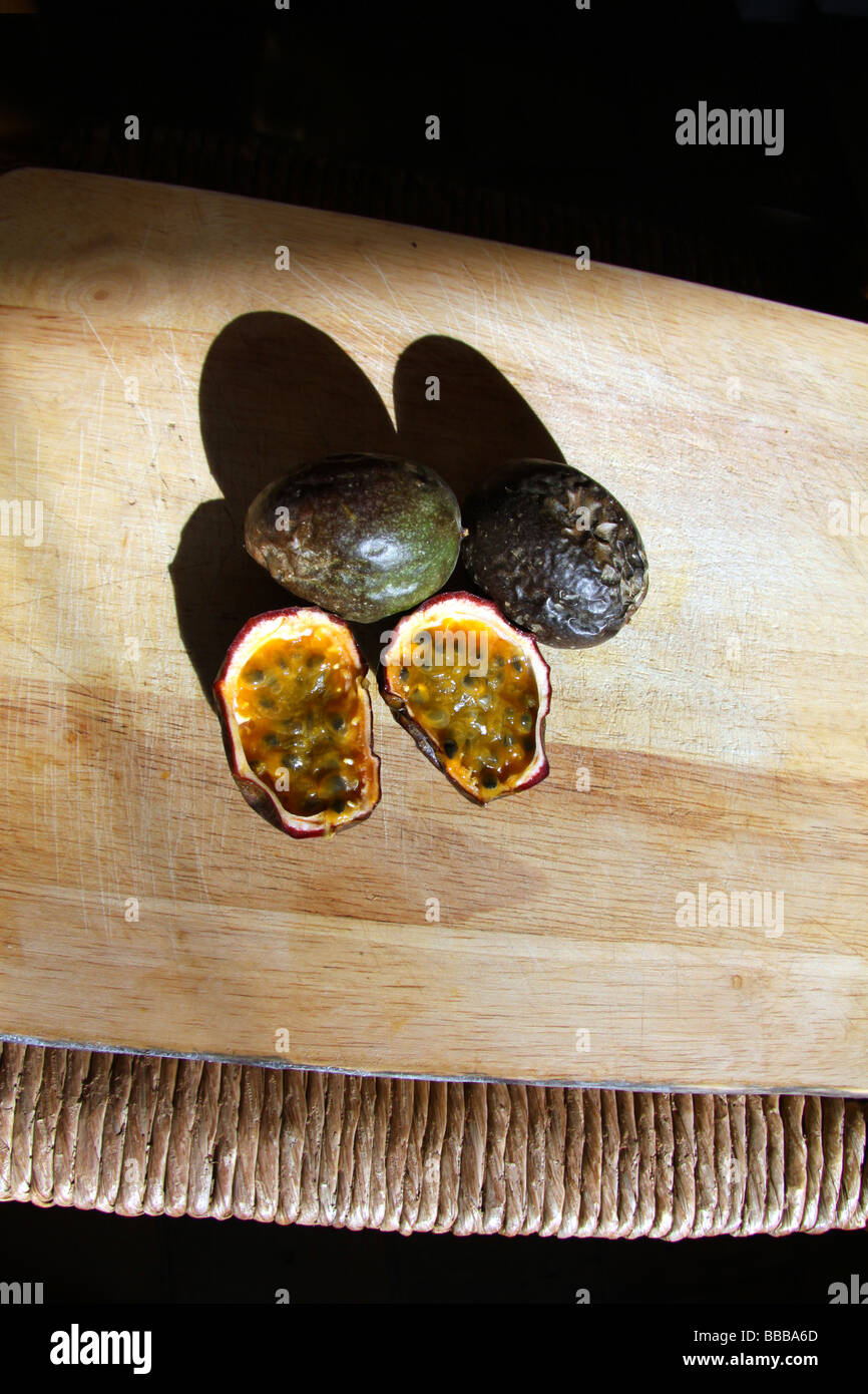 Image of three passion fruit, two whole and one split in half to show ...