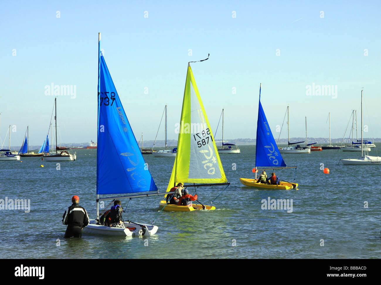 A family sailing day with three small boats in the foreground and lots ...