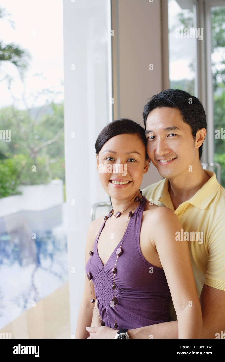 Couple next to a window, looking at camera, portrait Stock Photo - Alamy