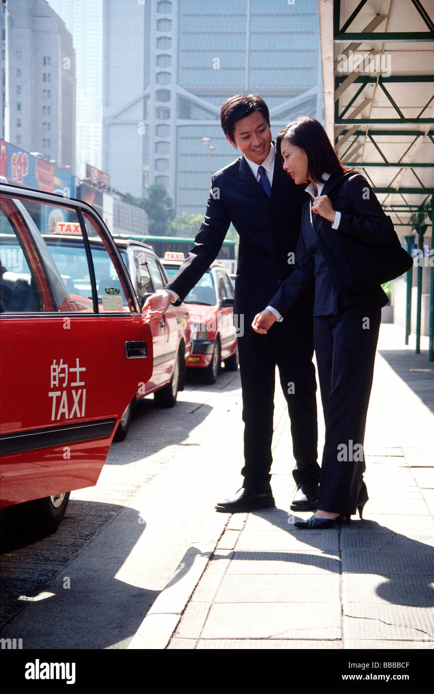 Two executives getting into taxi Stock Photo - Alamy