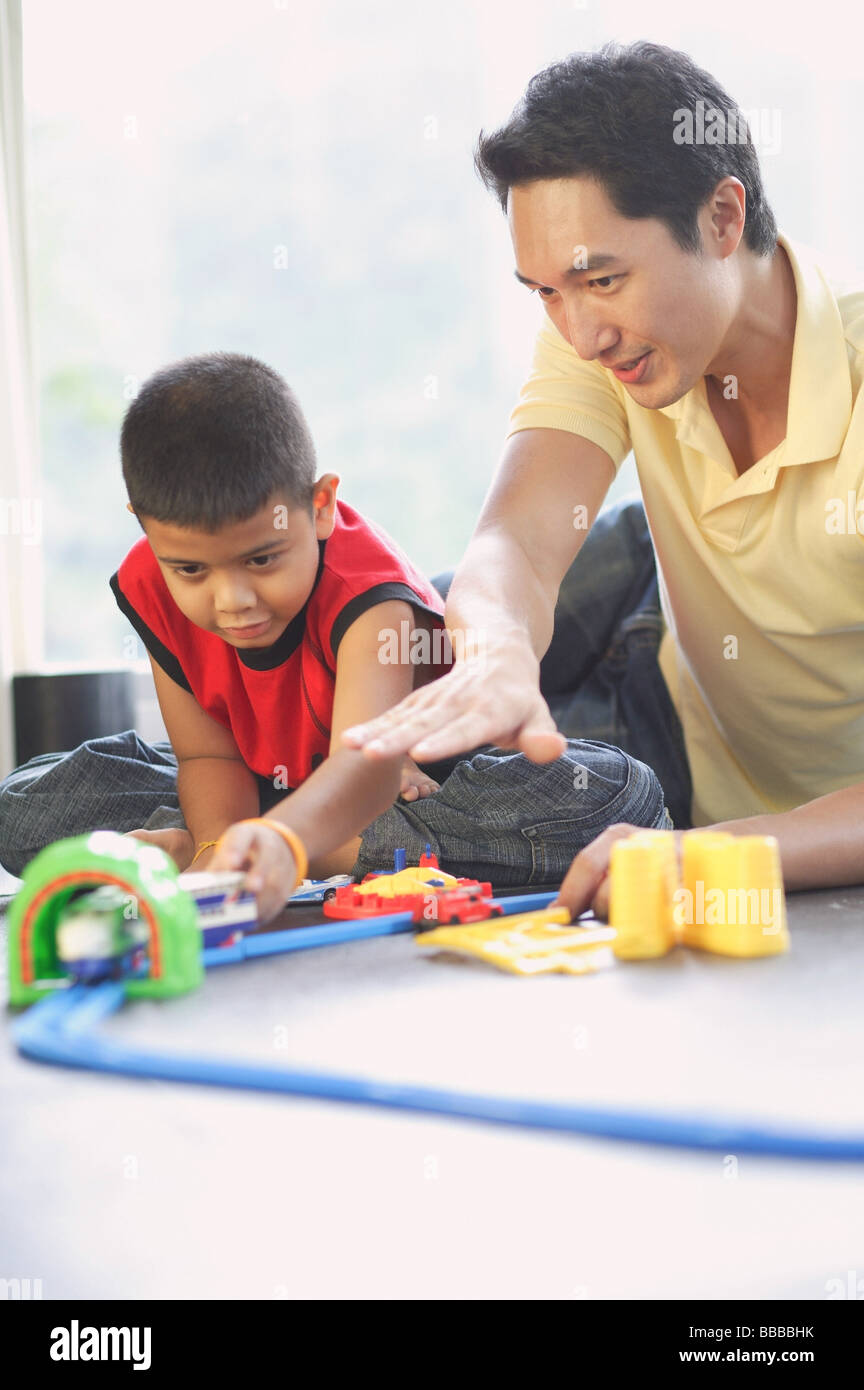 Father and son playing with train set Stock Photo - Alamy