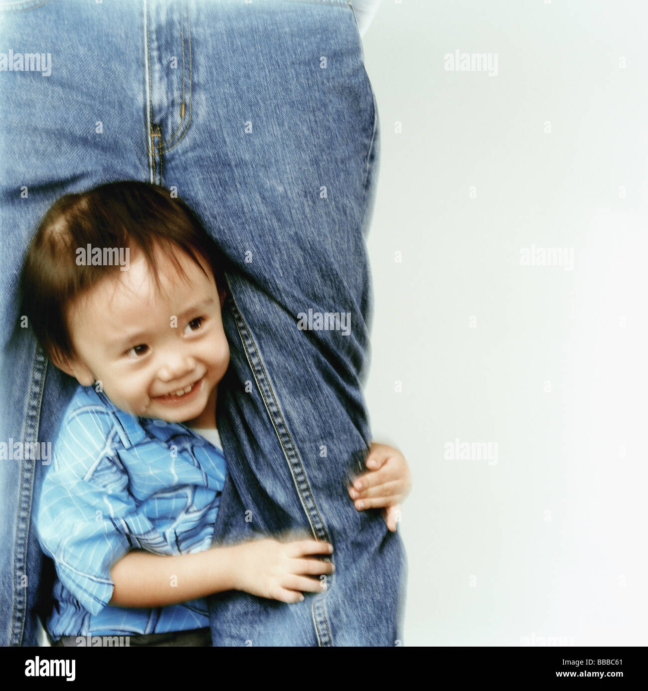 Young boy peeking between the legs of his father Stock Photo - Alamy