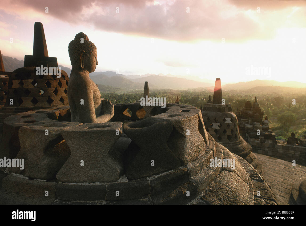 Indonesia, Java, Buddha figure at Borobudur temple at dawn, mountains ...