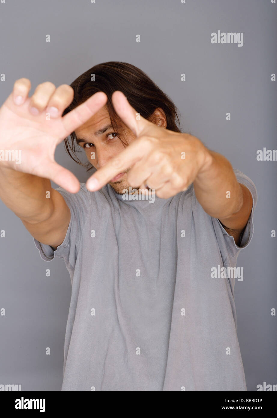 Man making finger frame, looking at camera Stock Photo - Alamy