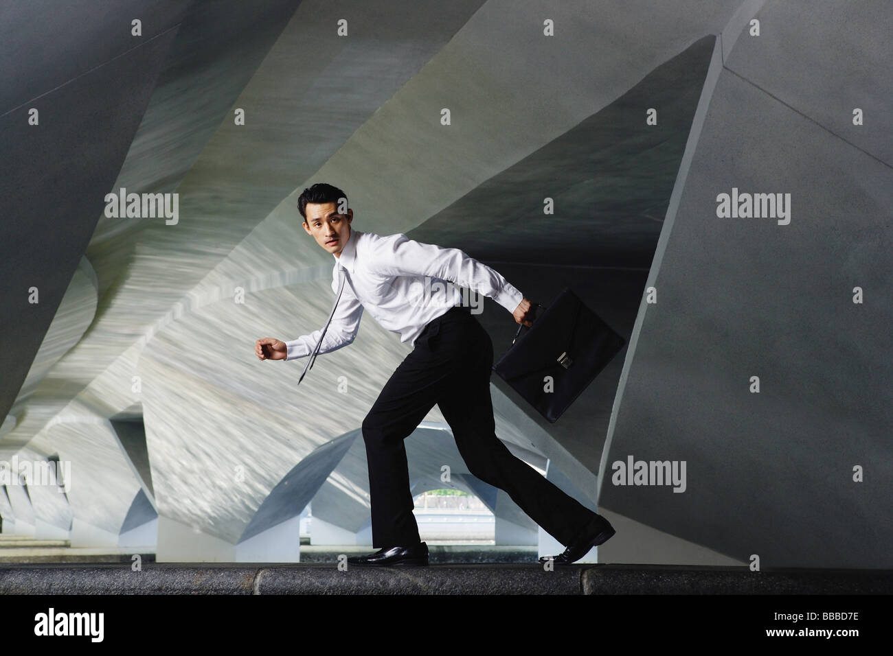 Executive in running pose, looking at camera Stock Photo - Alamy