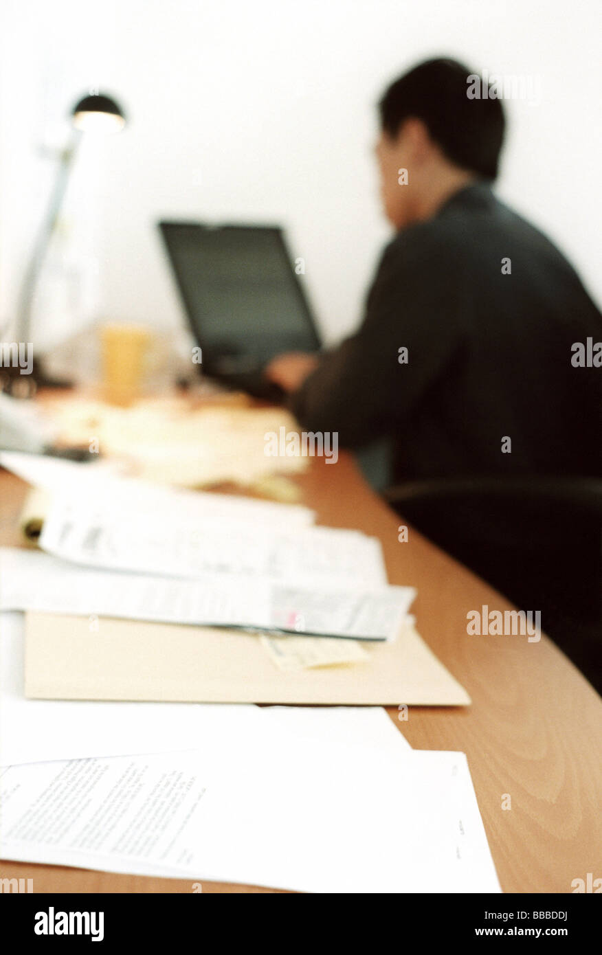 Male executive working on laptop, rear view Stock Photo - Alamy