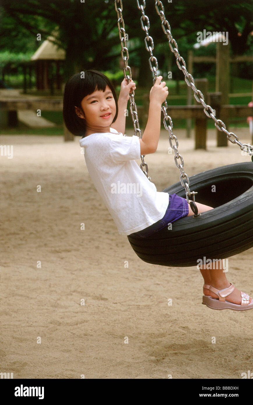 Girl playing on swing Stock Photo - Alamy