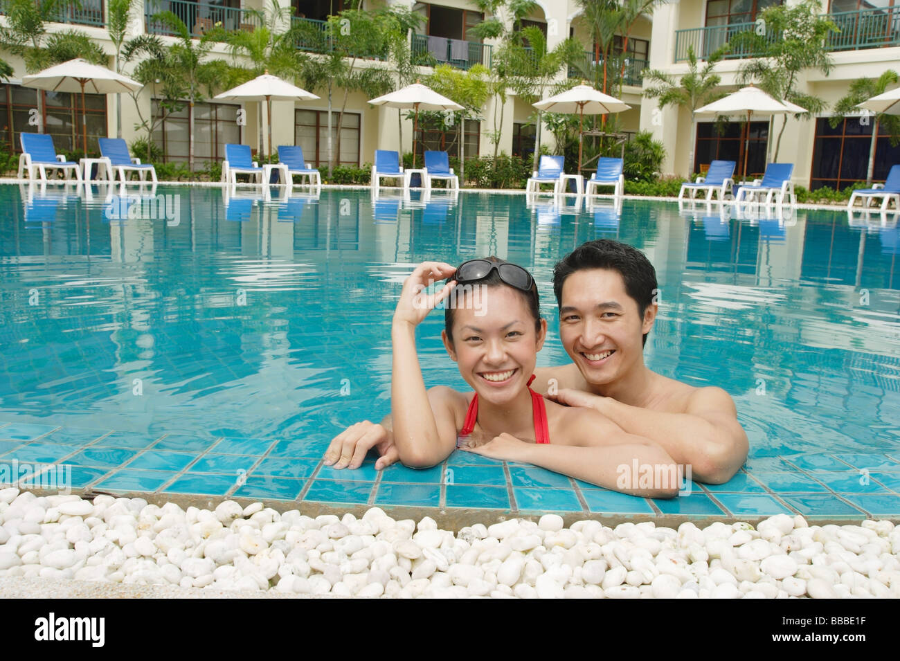 Couple in swimming pool, smiling at camera Stock Photo - Alamy