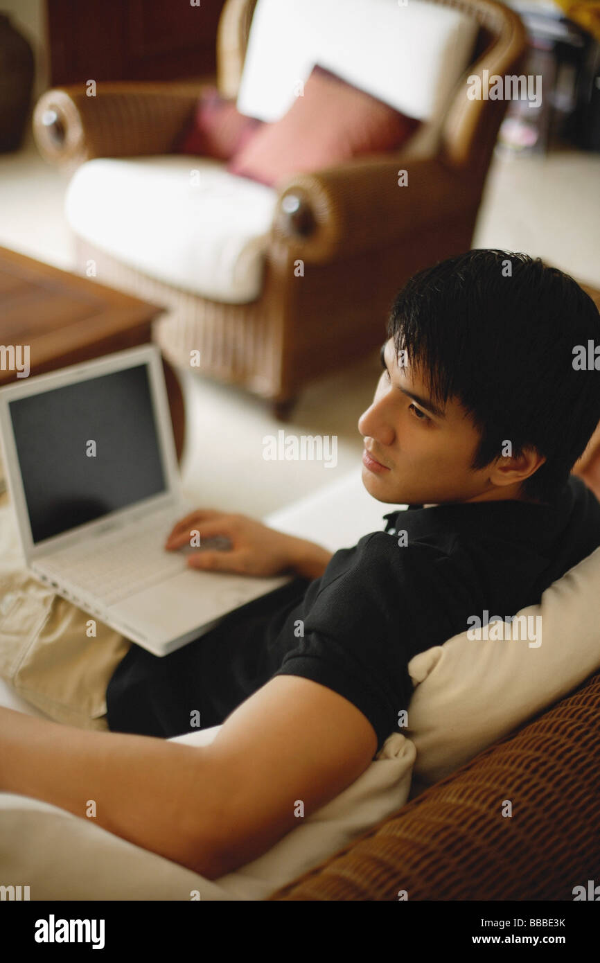 Man in living room with laptop on lap Stock Photo - Alamy